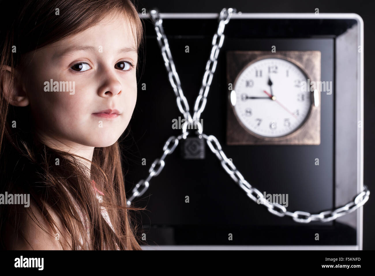 Young child, girl, TV closed with chain lock, clock Stock Photo - Alamy