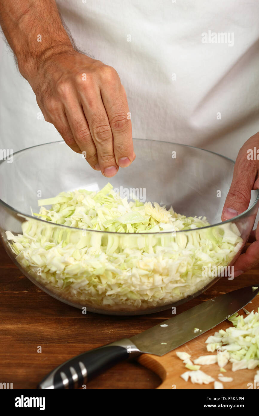 Cooking Cabbage. Pressing cabbage with salt in glass bowl Stock Photo ...