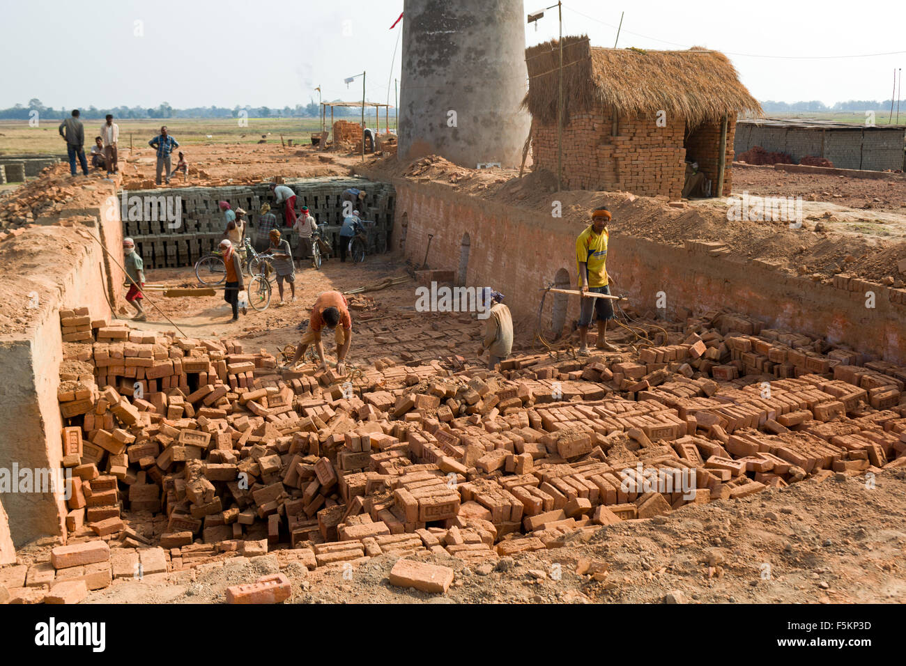 Workers are filling and emtying the kiln of a brickyard with clay ...