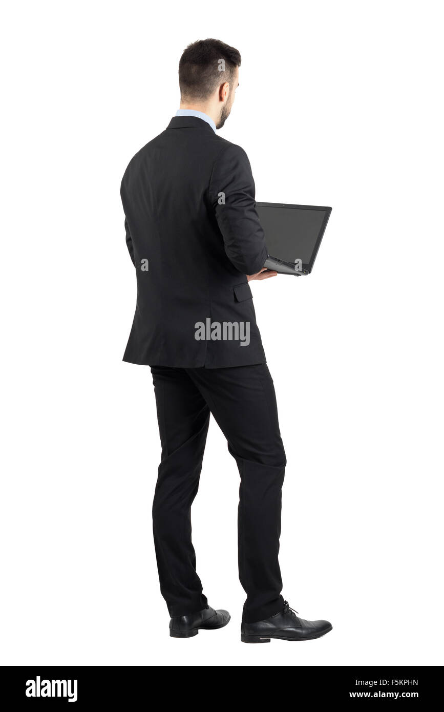 Rear view of young man in suit using laptop. Full body length portrait ...