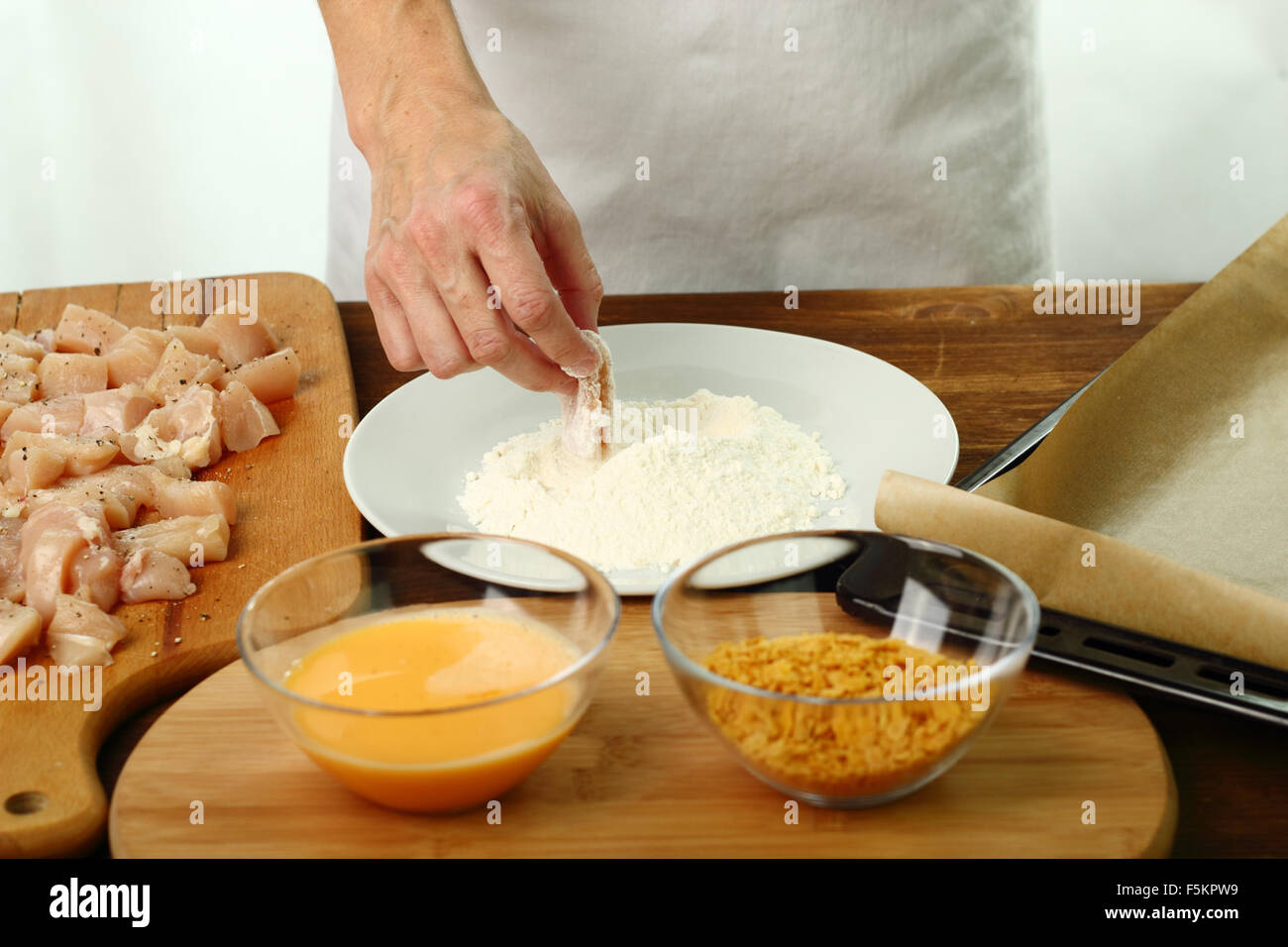 Roll chicken fillet in flour. Making oven baked corn flake crumbs ...