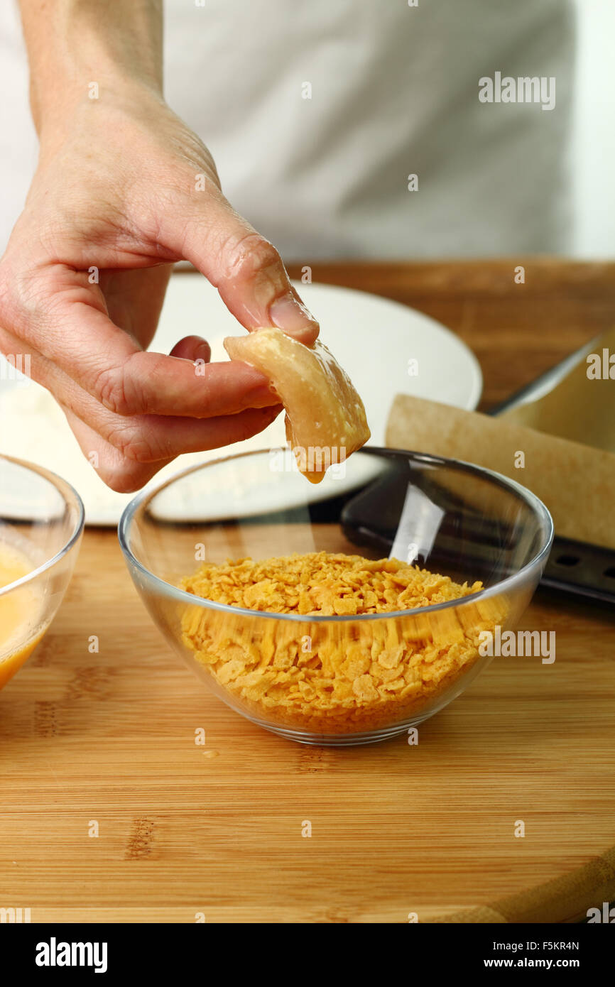 Roll floured, egged chicken fillet in corn flake crumbs. Making oven ...