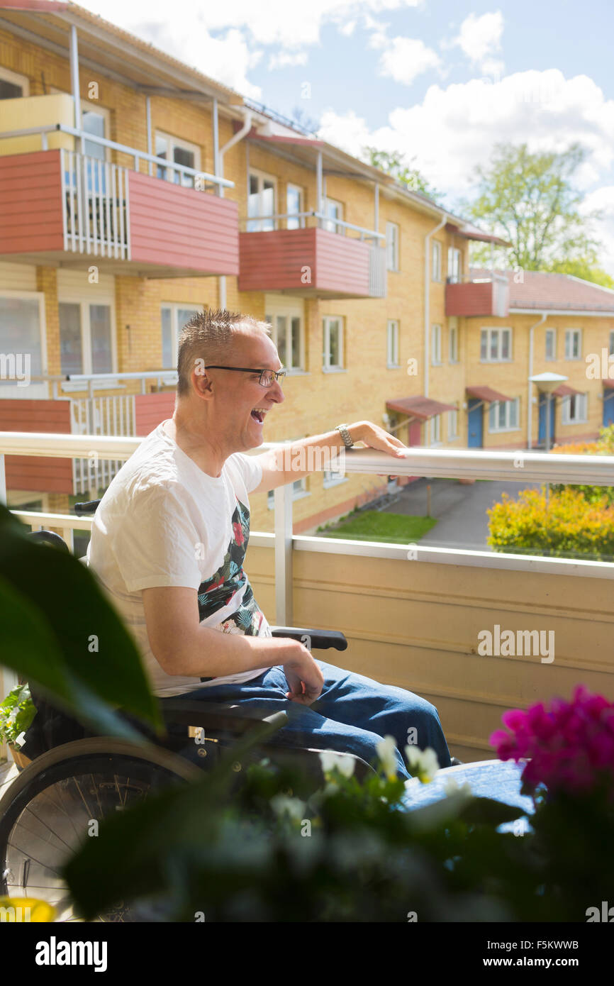 Sweden, Ostergotland, Mjolby, Man on wheelchair on balcony Stock Photo ...