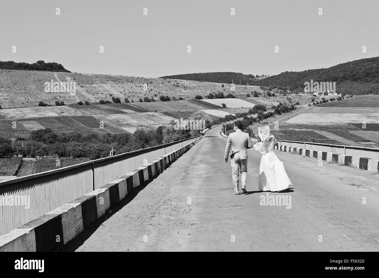 Young happy wedding couple at the road bridge Stock Photo - Alamy
