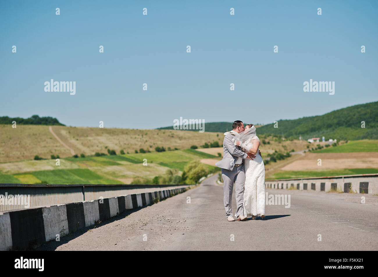 Young happy wedding couple at the road bridge Stock Photo - Alamy