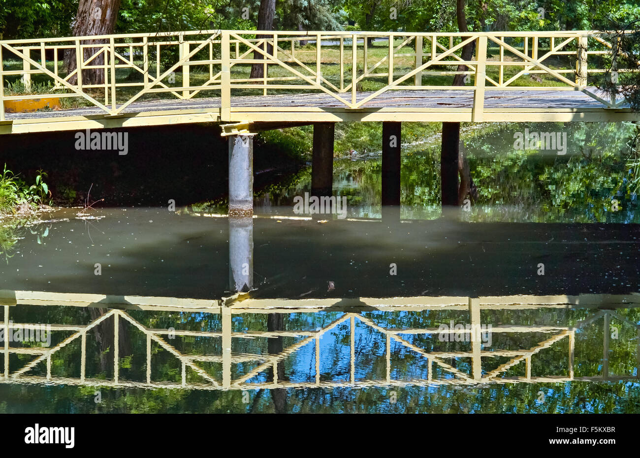 Metal footbridge over the stream in the city park Stock Photo - Alamy