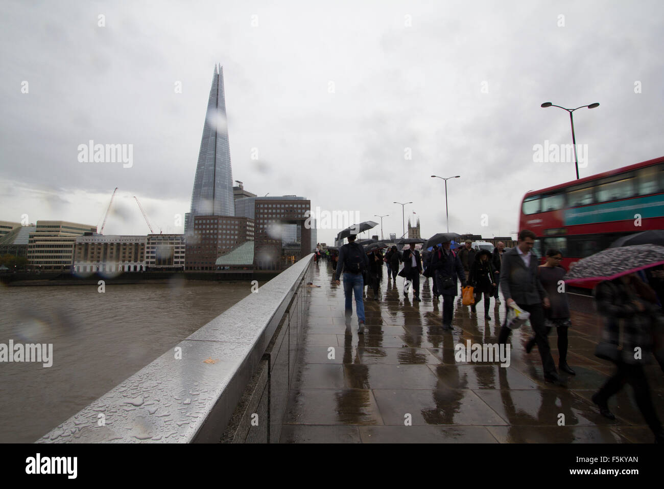 Rain Rainstorm on London bridge during morning rush hour, with Shard in ...
