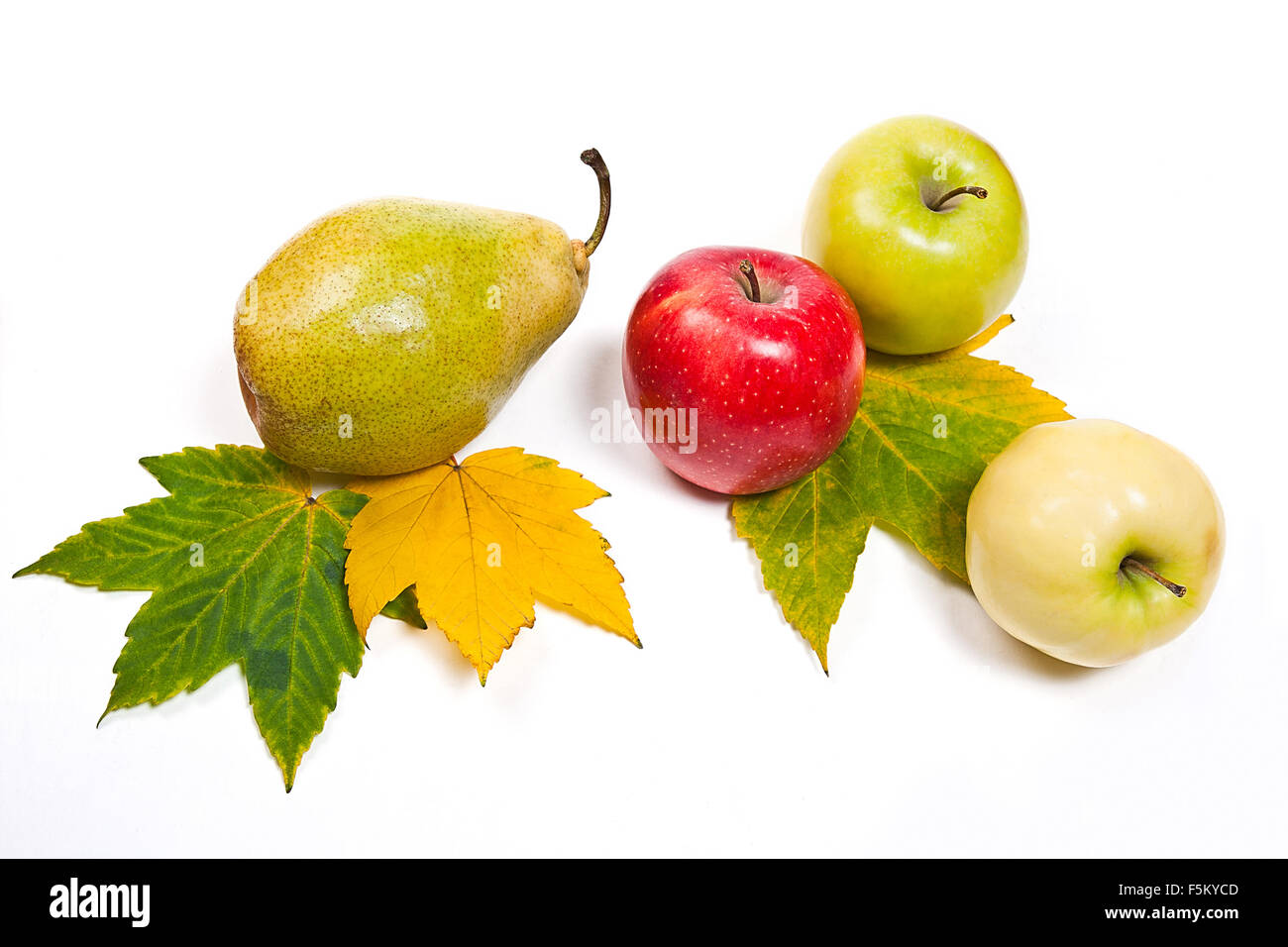 Fresh green pear and two apples in red and green color on the yellow ...