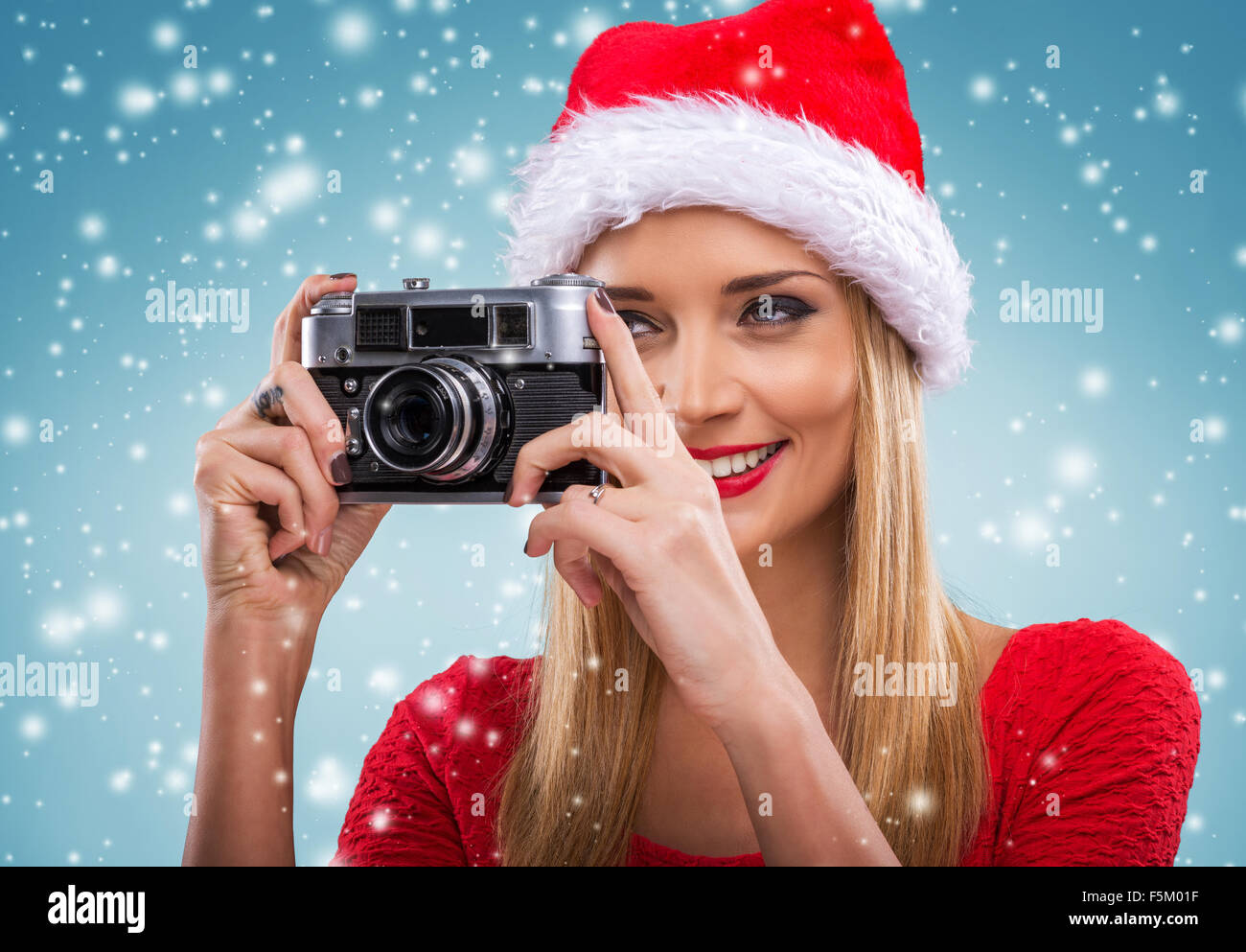 Beautiful santa woman holding camera, snowfall background Stock Photo ...