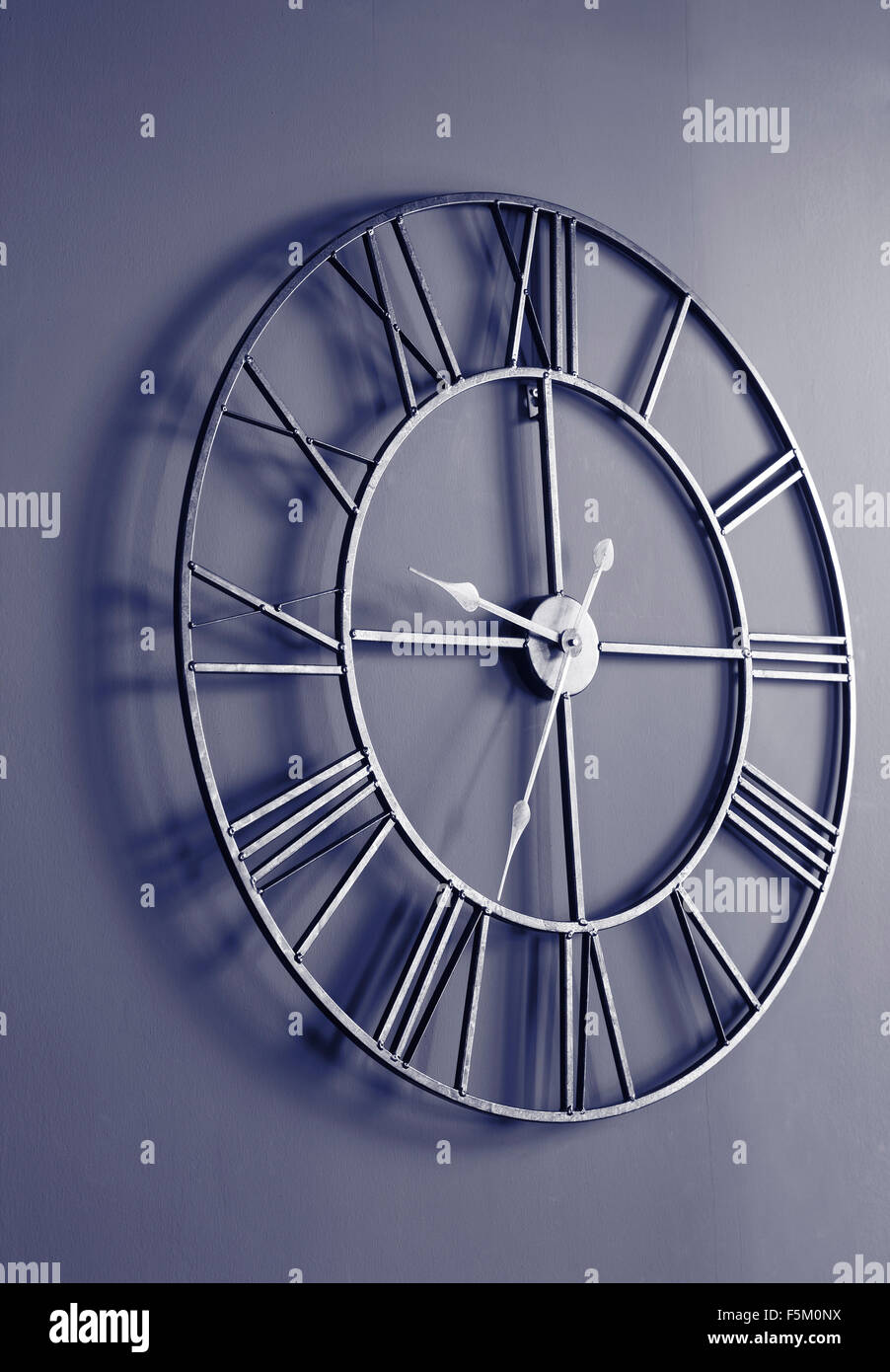 Wall clock with roman numbers blue tone treatment Stock Photo - Alamy