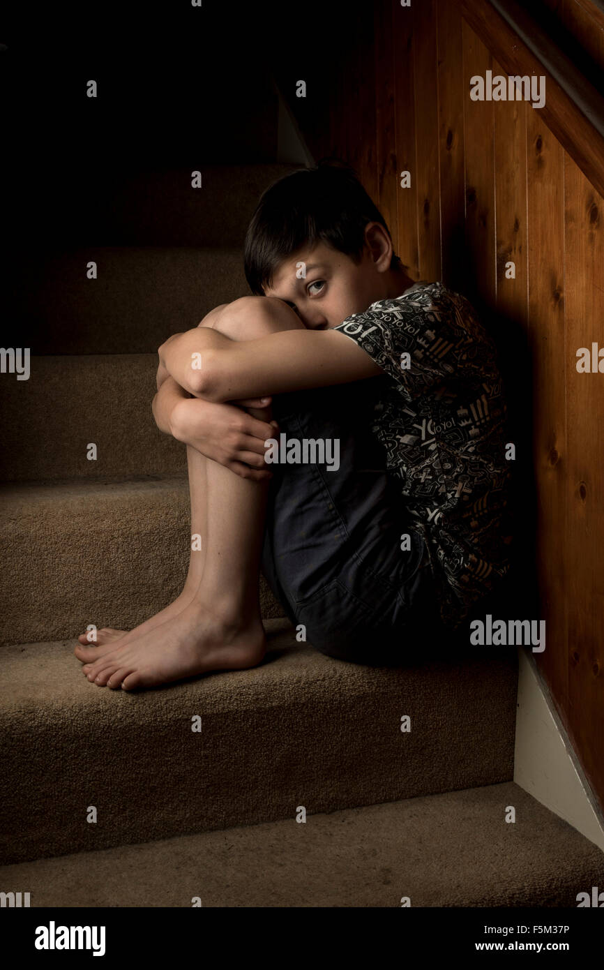 Sad, bullied or abused boy sitting on the stairs Stock Photo - Alamy