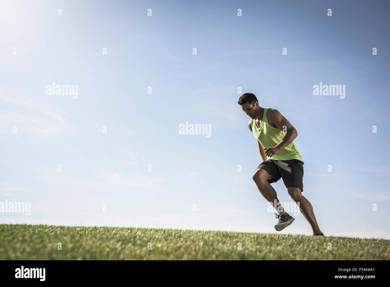 Young man agility running on park hill Stock Photo - Alamy
