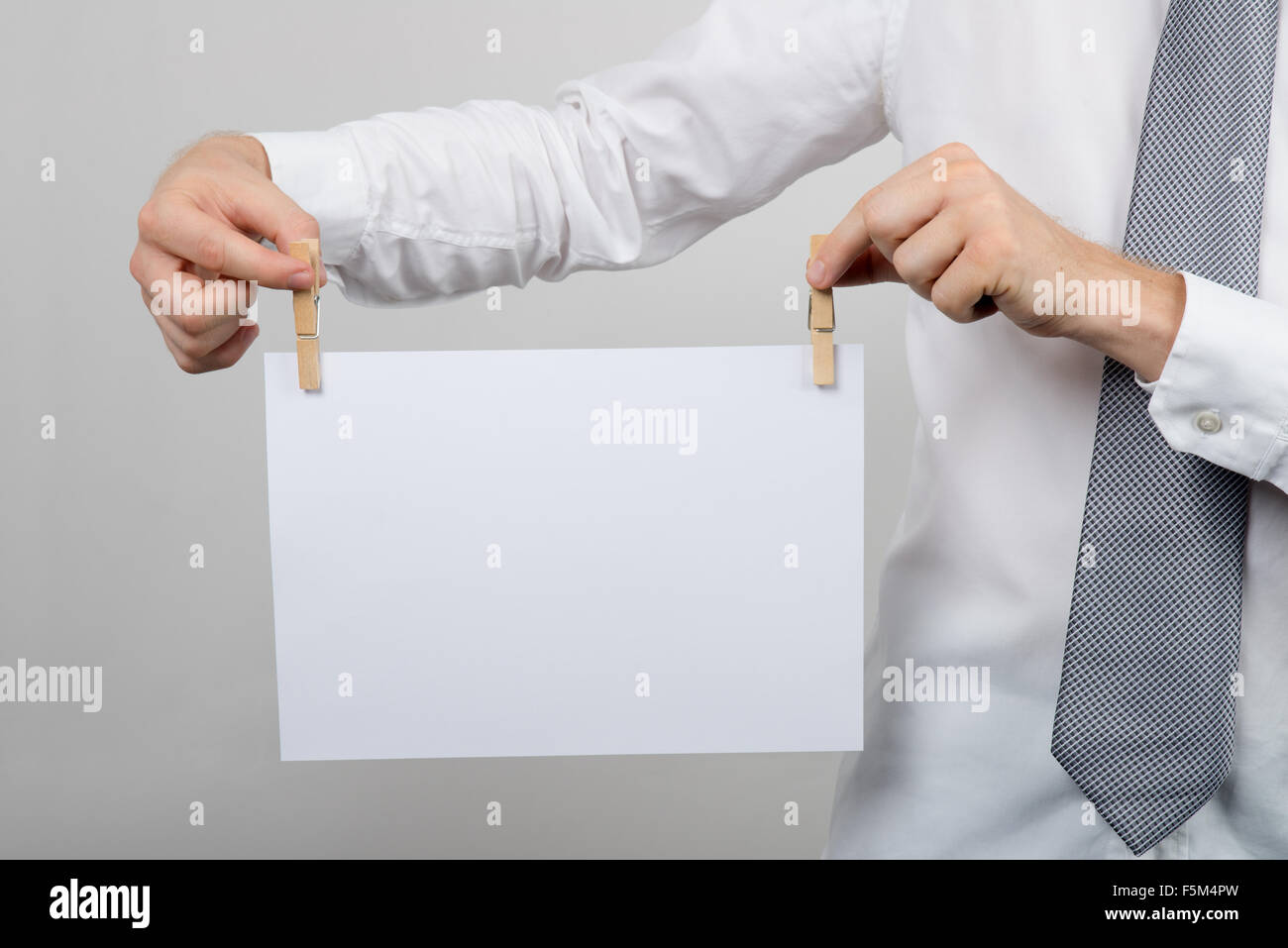 Office worker holding blank piece of paper Stock Photo - Alamy