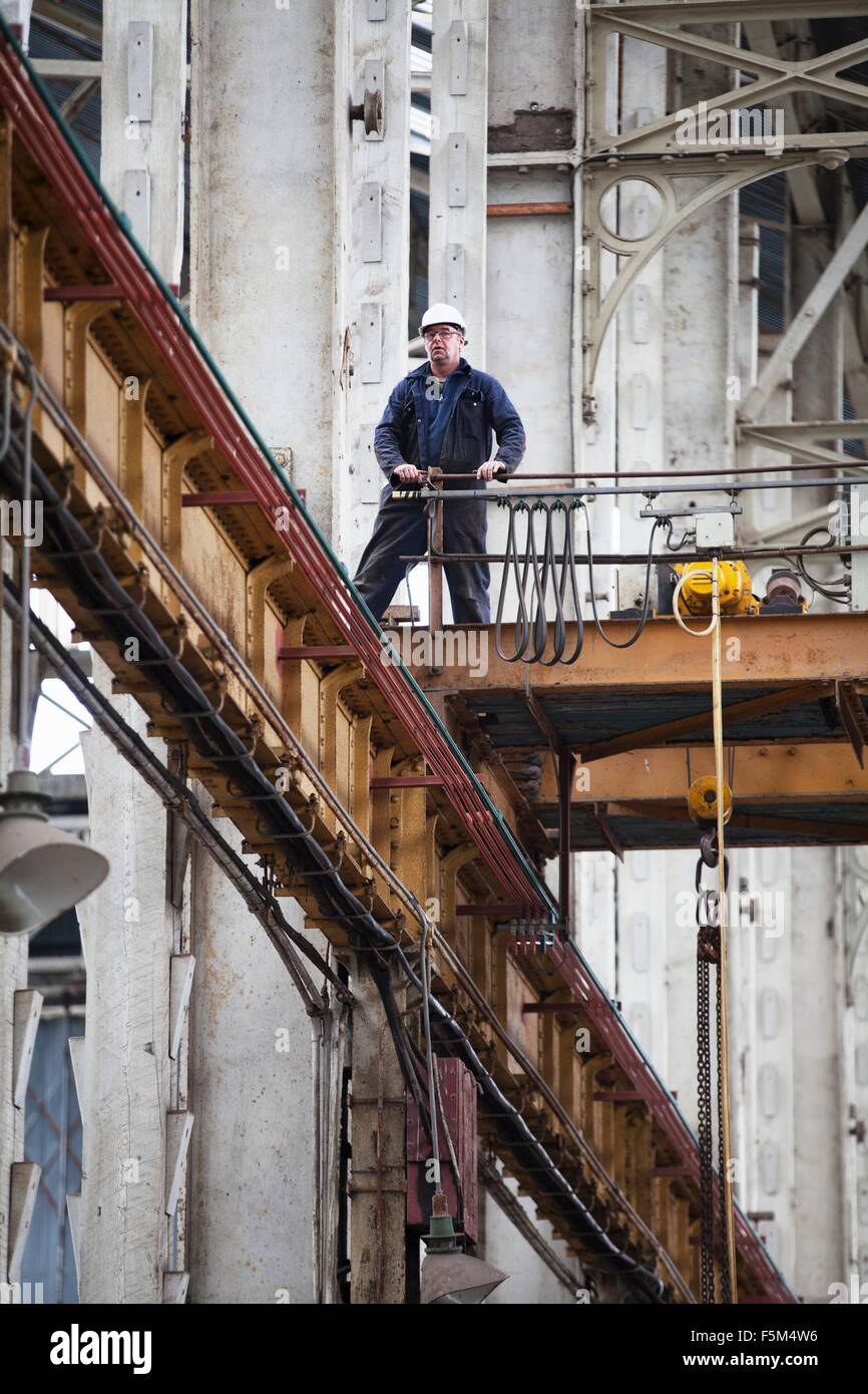 Worker on gantry in shipyard workshop Stock Photo - Alamy