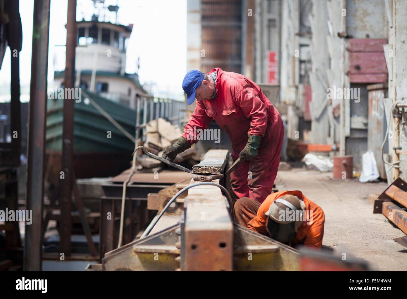 Workers doing maintenance in shipyard workshop Stock Photo - Alamy