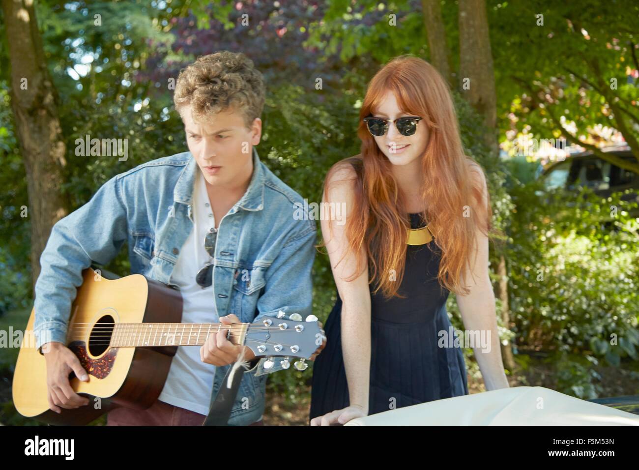 Young couple playing acoustic guitar Stock Photo - Alamy