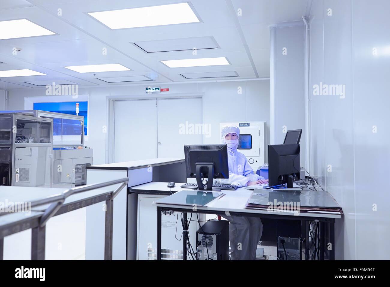 Female factory worker using computers in flexible electronics factory ...