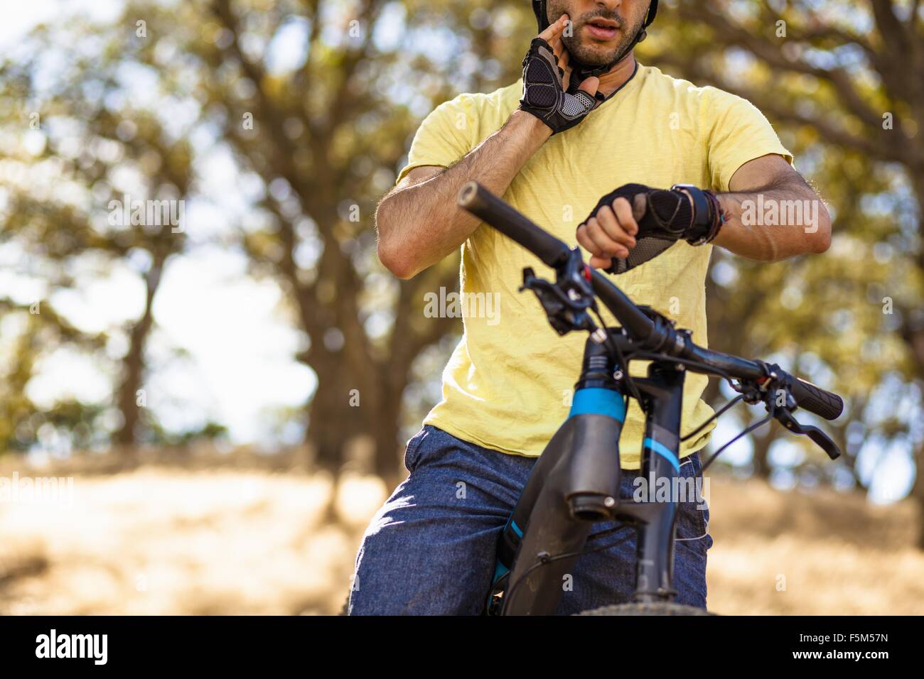Cropped view of young male mountain biker checking smartwatch, Mount ...