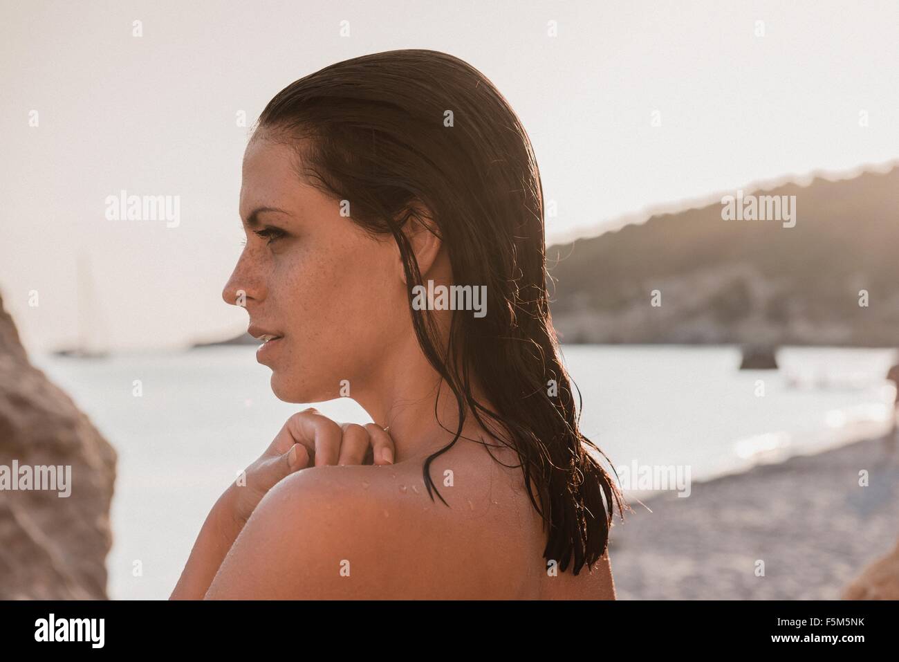 Bare shouldered young woman on beach, Menorca, Balearic Islands, Spain ...