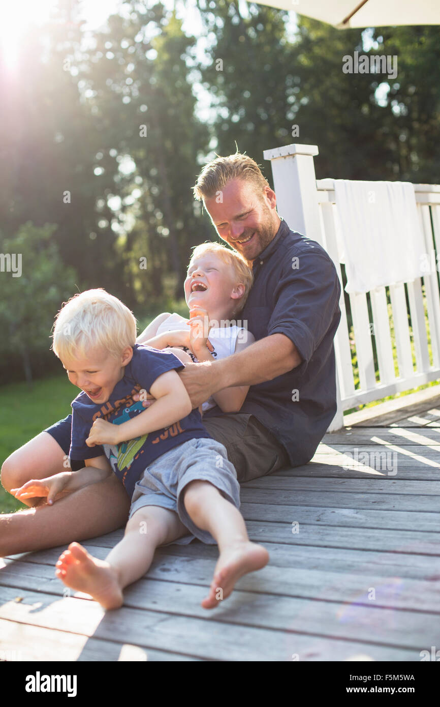 Sweden, Stockholm Archipelago, Grasko, Father playing with sons (4-5, 6 ...