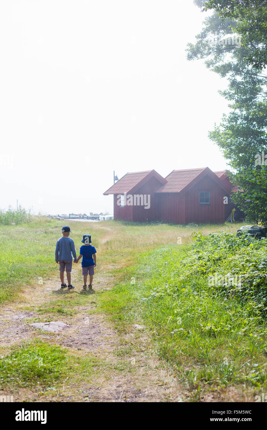 Sweden, Stockholm Archipelago, Grasko, Two boys (4-5, 6-7) holding ...