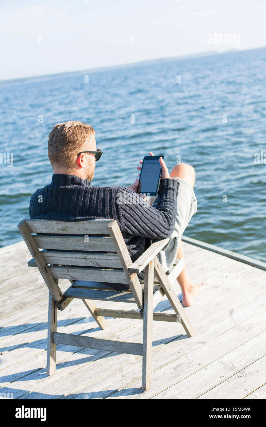 Man sitting on dock hi-res stock photography and images - Alamy