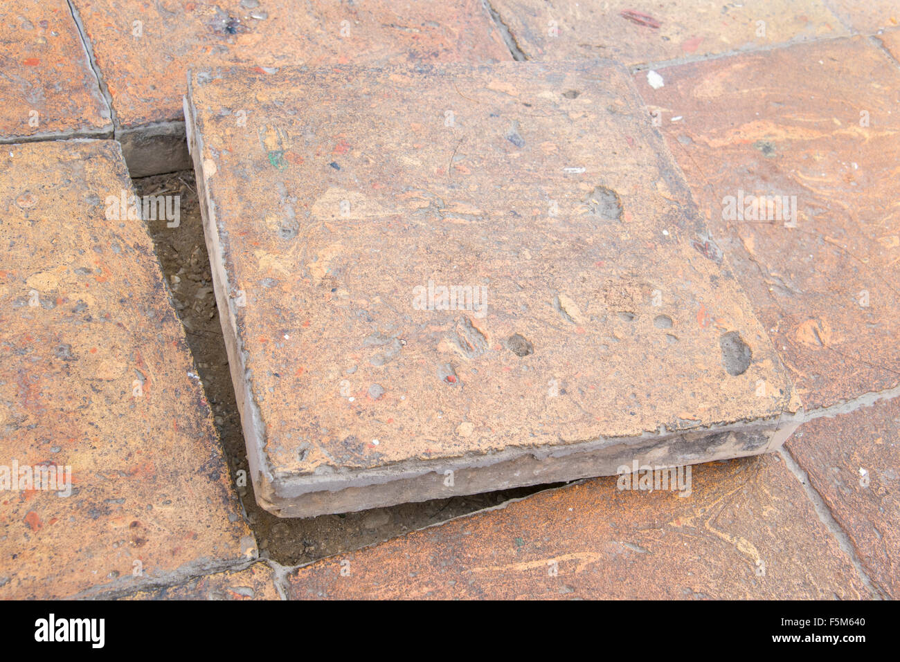 Clay floor tile on sand being lifted Stock Photo - Alamy
