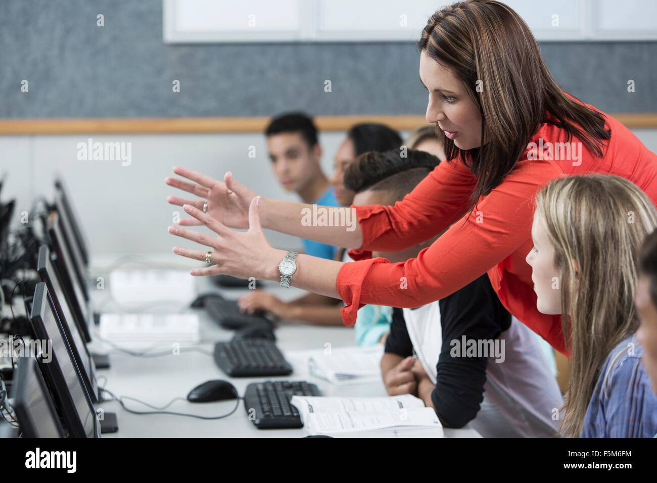 Female teacher explaining to high school students in class Stock Photo ...