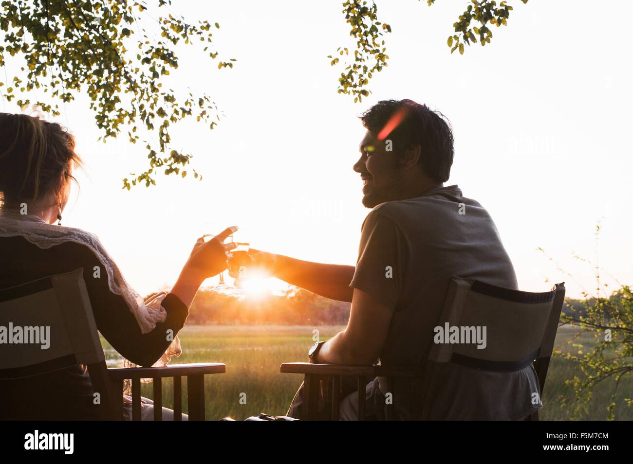 Couple drinking wine at sunset at safari lodge, Kafue National Park ...