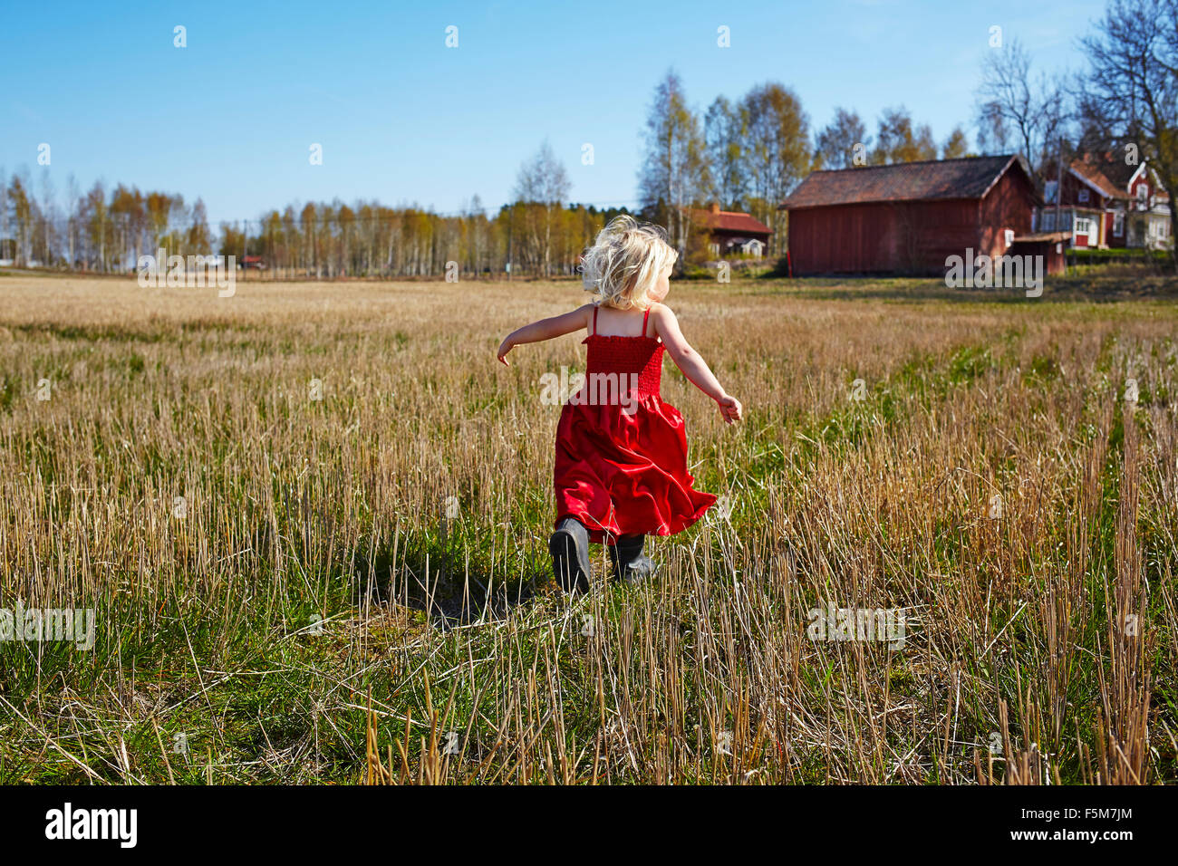 Sweden, Vastra Gotaland, Gullspang, Girl (4-5) wearing red dress ...