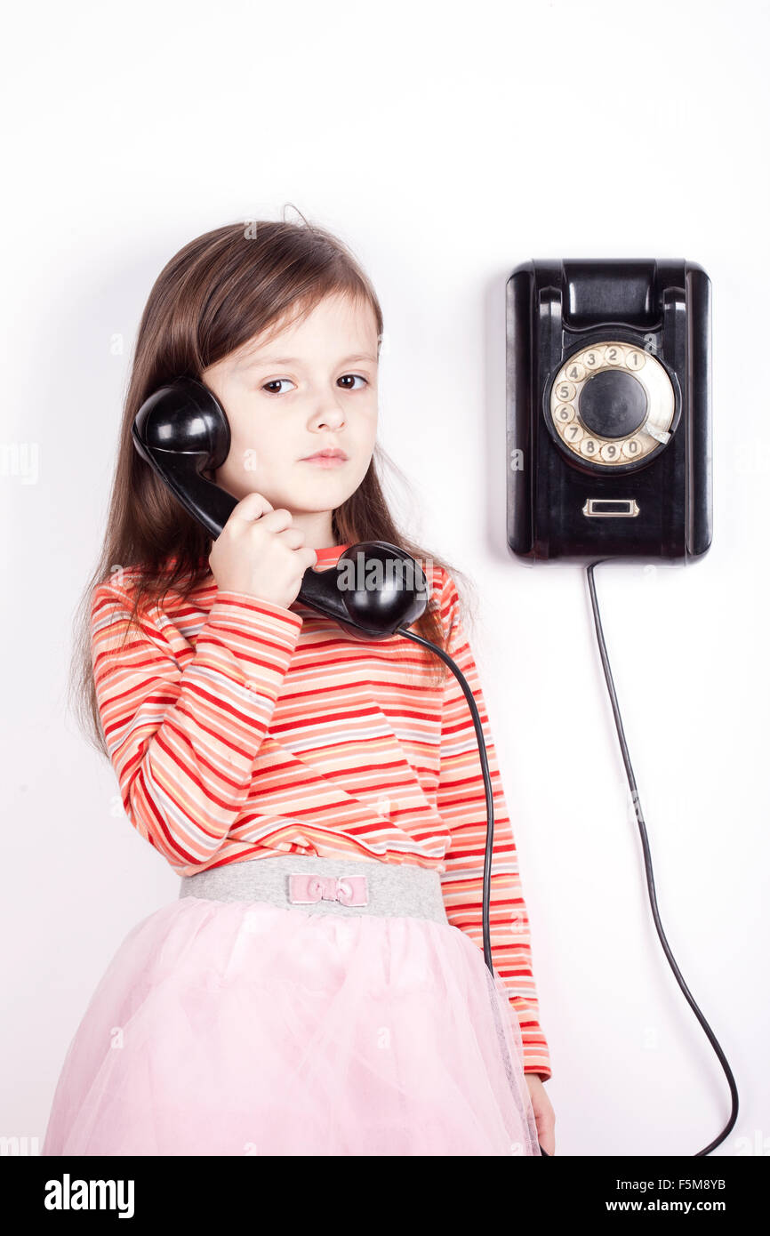 Serious sad child talking on phone, white background Stock Photo - Alamy