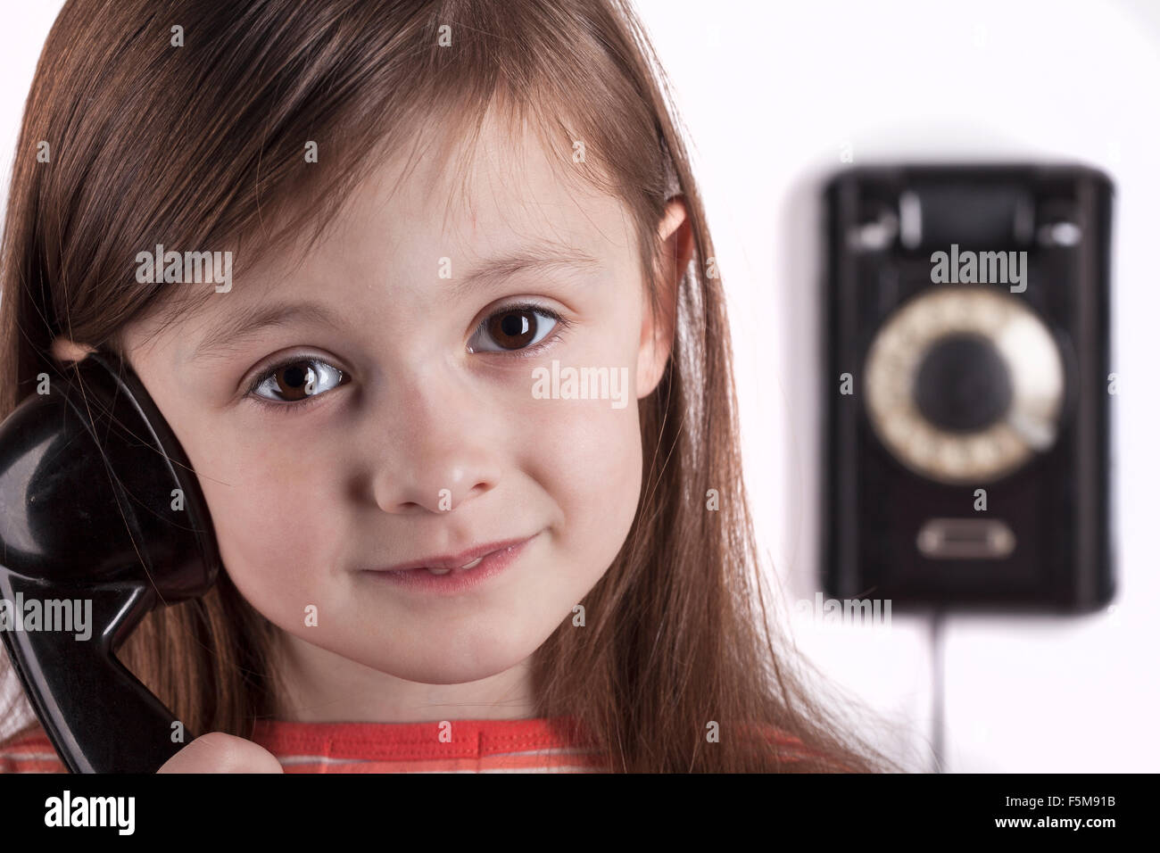 Laughing child talking on phone, white background Stock Photo - Alamy