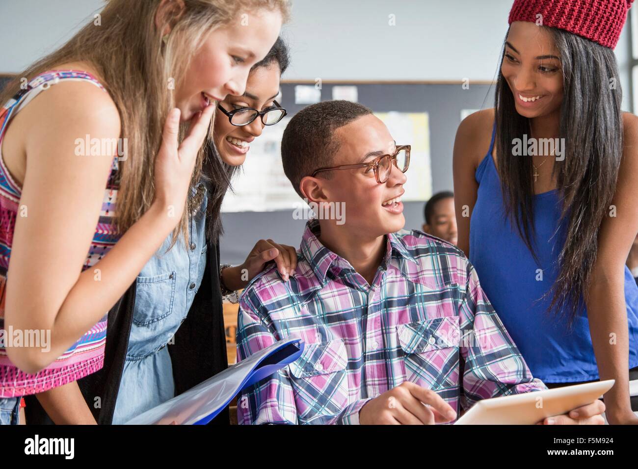 Group of students in classroom, looking at digital tablet Stock Photo ...