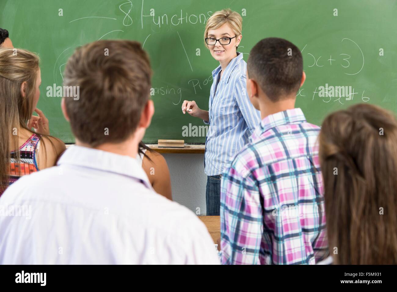 Teacher addressing students in classroom Stock Photo - Alamy