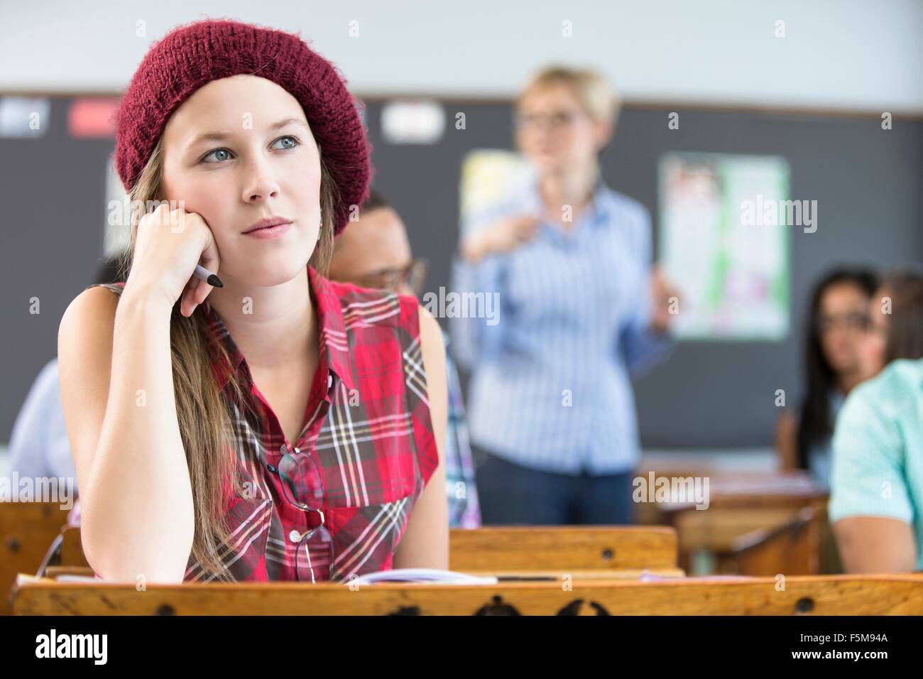 Female student, sitting at desk in classroom, thinking Stock Photo - Alamy