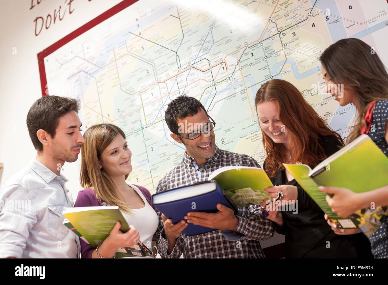 Small group of people, looking through study books Stock Photo - Alamy
