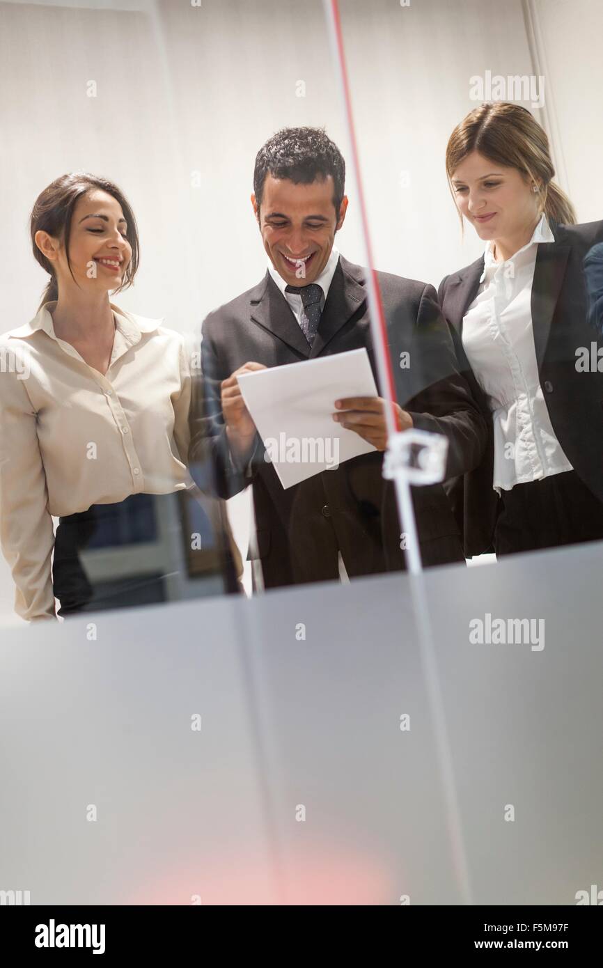 Three colleagues looking through documents in office Stock Photo - Alamy