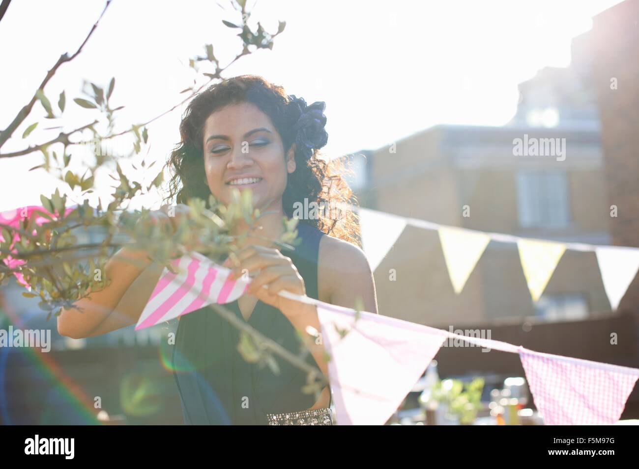 Woman hanging bunting for early evening party Stock Photo - Alamy