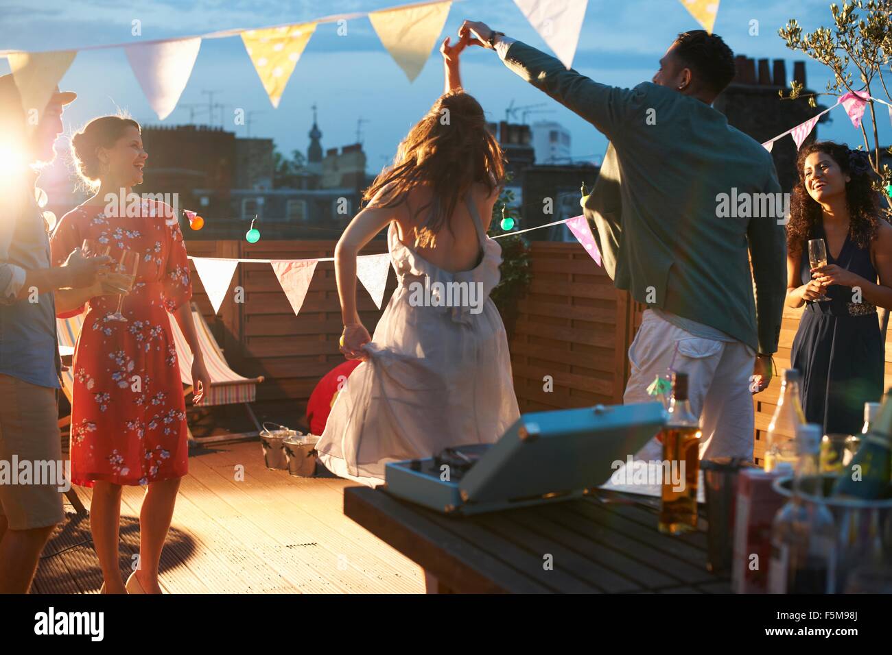 Friends dancing at early evening party Stock Photo - Alamy