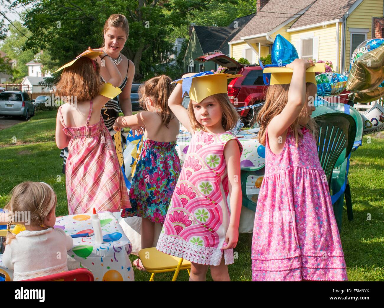 Group of children at kindergarten graduation, wearing paper mortar ...