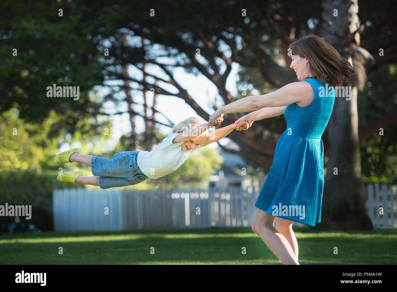 Mother swinging son around, outdoors Stock Photo - Alamy