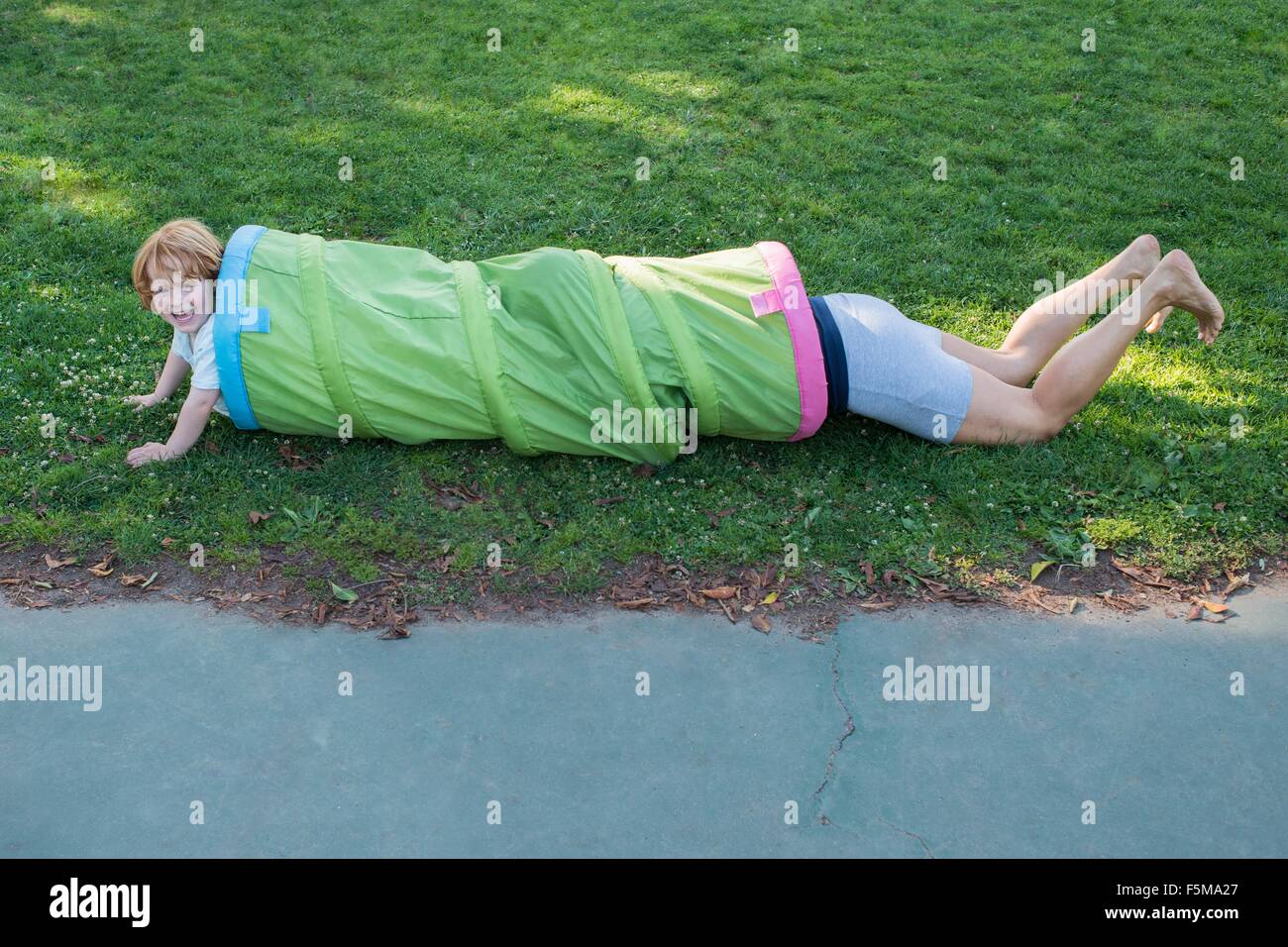 Mother and son crawling through play tube in garden Stock Photo - Alamy