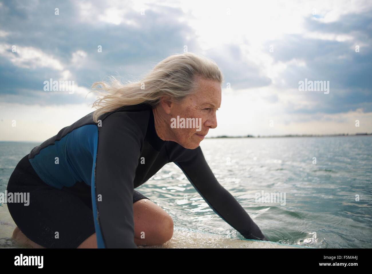 Senior woman on surfboard in sea, paddleboarding Stock Photo - Alamy