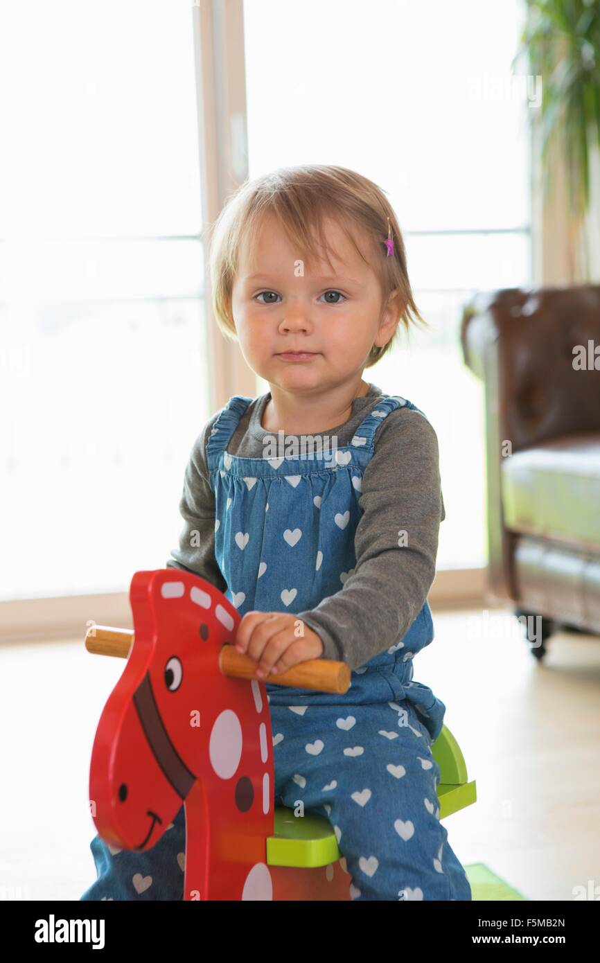 Portrait of female toddler playing on rocking horse Stock Photo - Alamy