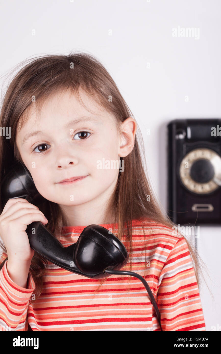 Serious child talking on phone, white background Stock Photo - Alamy