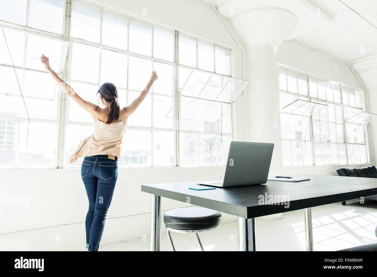 Businesswoman dancing by office window Stock Photo - Alamy