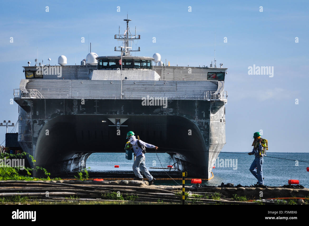 Workers pull out ables as they walk past the USNS Millinocket, a ...