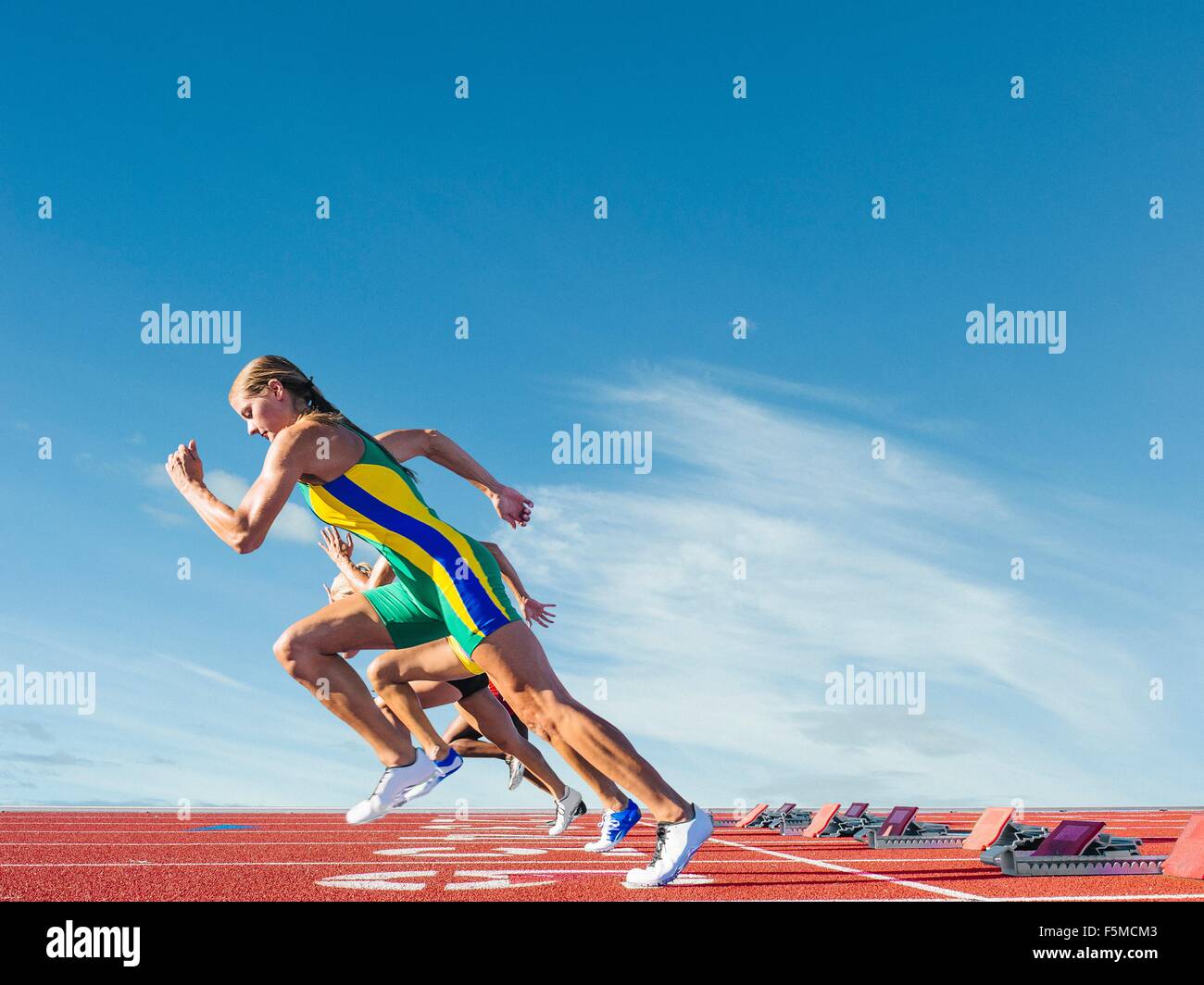 Three female athletes on athletics track, racing Stock Photo - Alamy