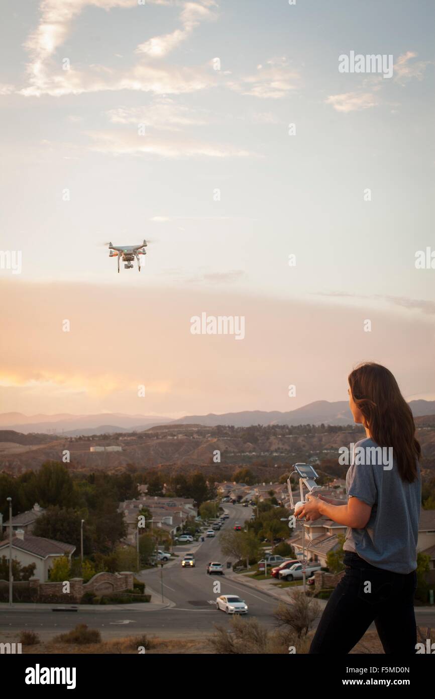 Female commercial operator flying drone above housing development ...