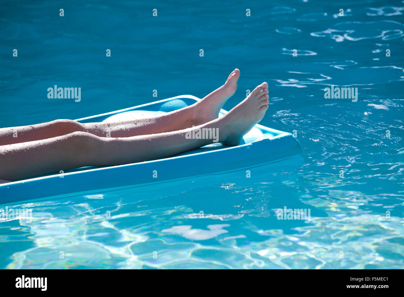 legs floating on a pool lilo Stock Photo - Alamy